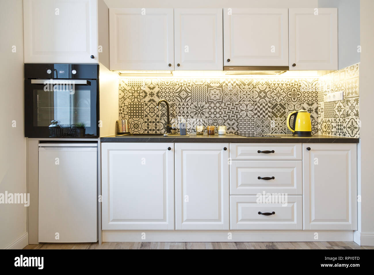 Beautiful home kitchen with white cabinets and backlight Stock Photo ...
