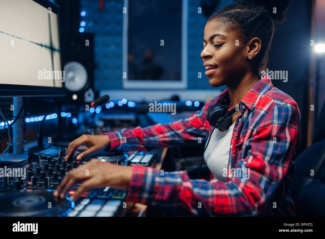 Female sound engineer working at the remote control panel in the ...