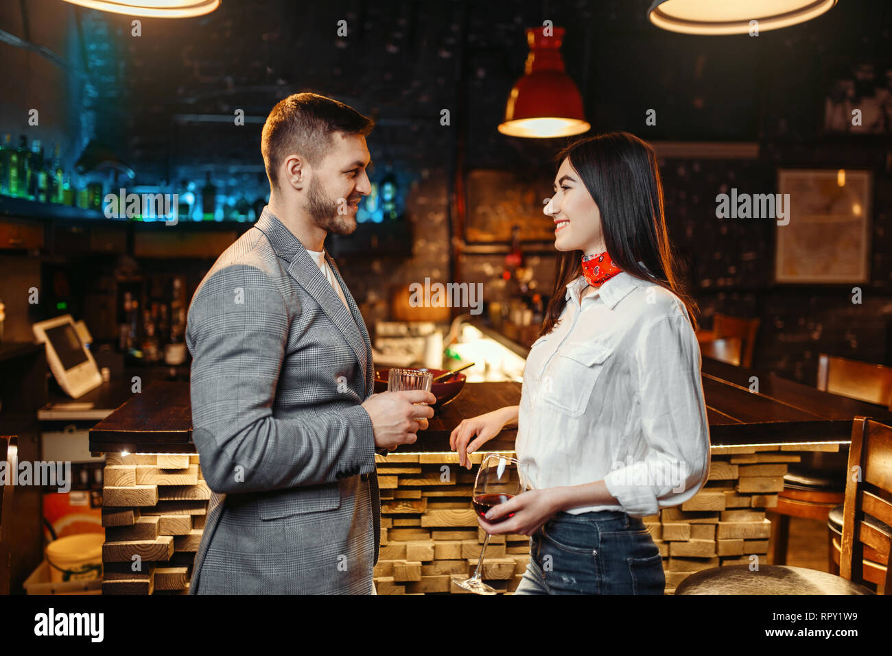 Love couple with alcoholic beverages talking at bar counter, romantic ...