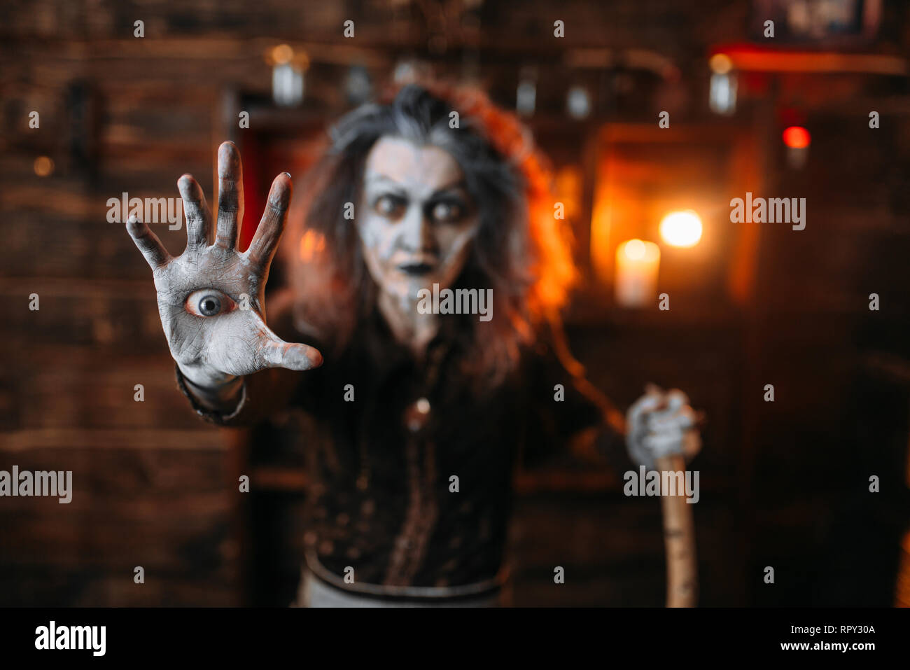 Scary witch with an eye in the palm reads mystic spell, spiritual ...