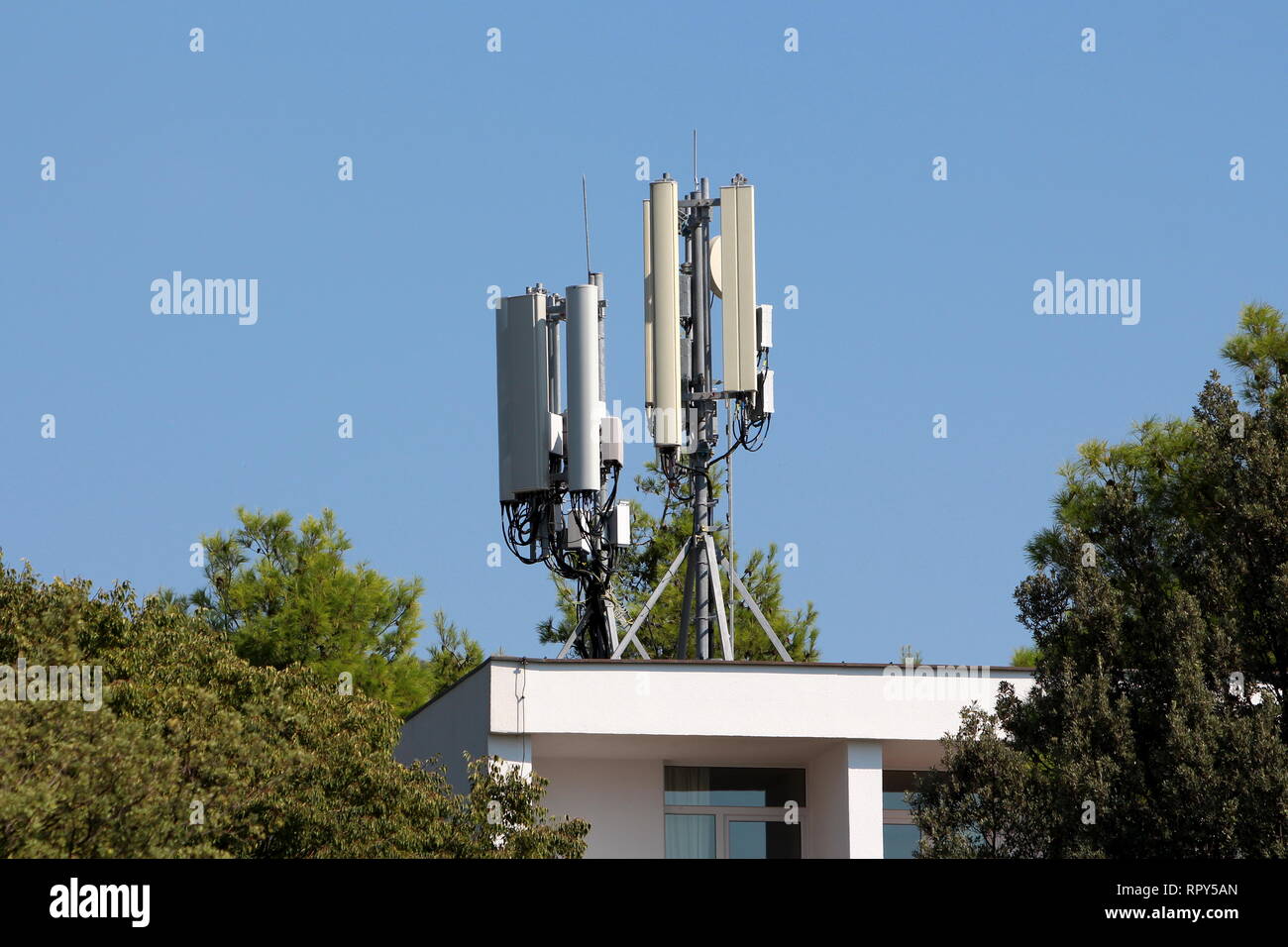 Multiple cell phone antenna transmitters on top of business building ...