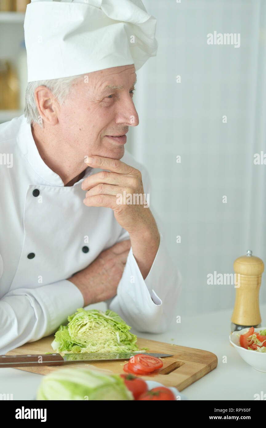 Portrait of elderly male chef cooking at kitchen Stock Photo - Alamy