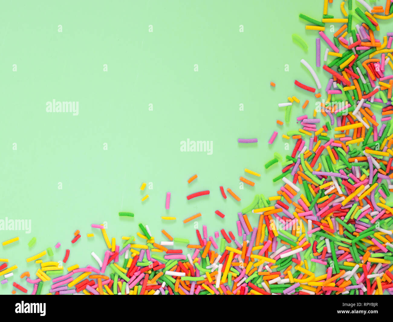 Border frame of colorful sprinkles on green background with copyspace ...
