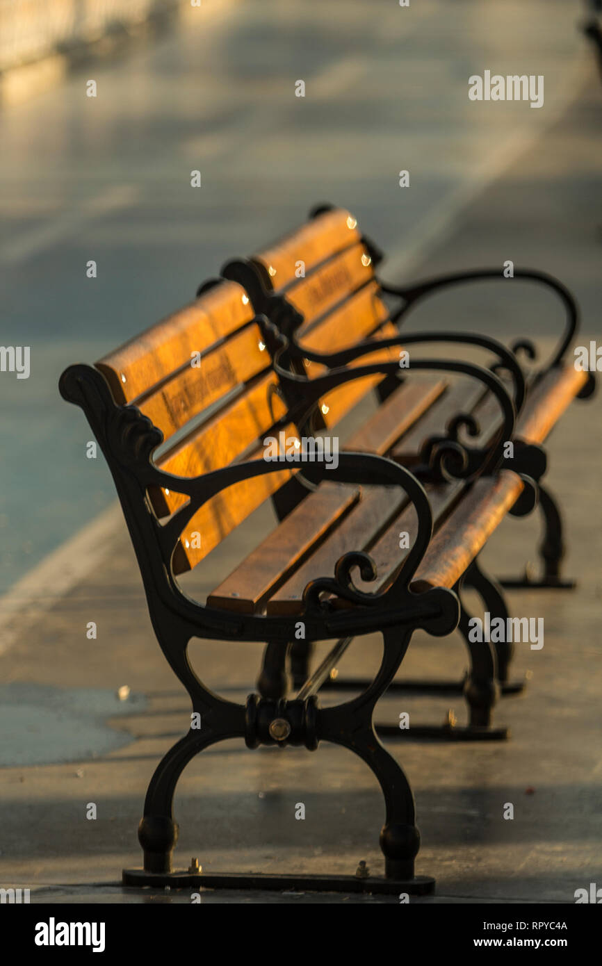 A couple of street benches under morning sun Stock Photo - Alamy