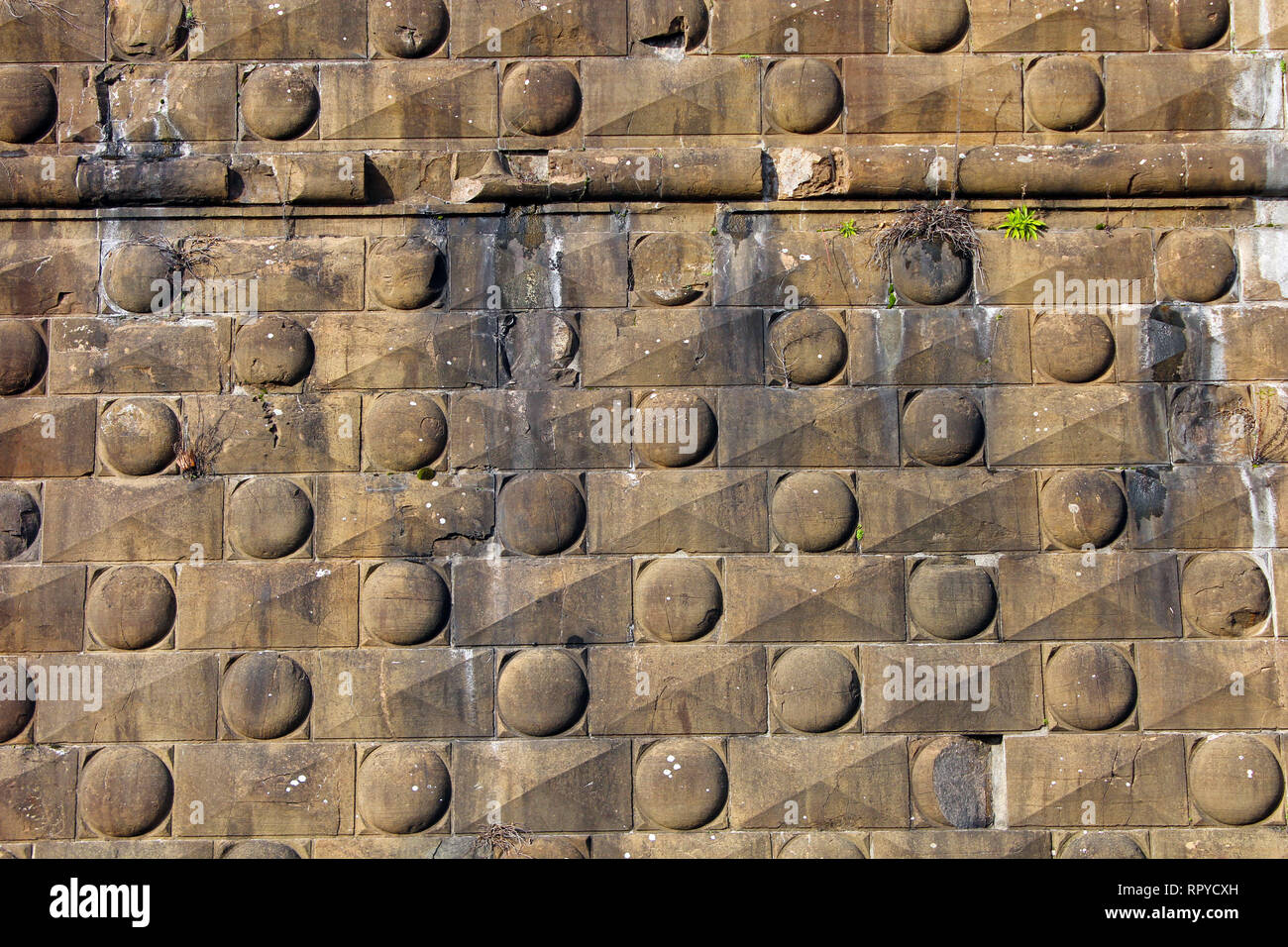 Fortress wall with carved stones of round and rectangular shapes Stock ...