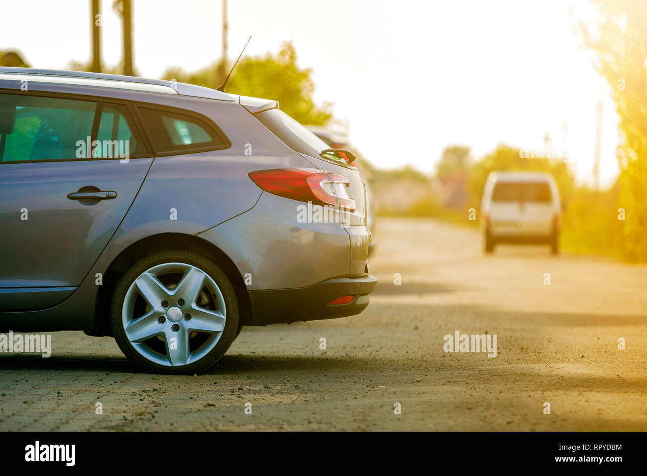 Side view detail of silver car parked in paved parking lot area on ...