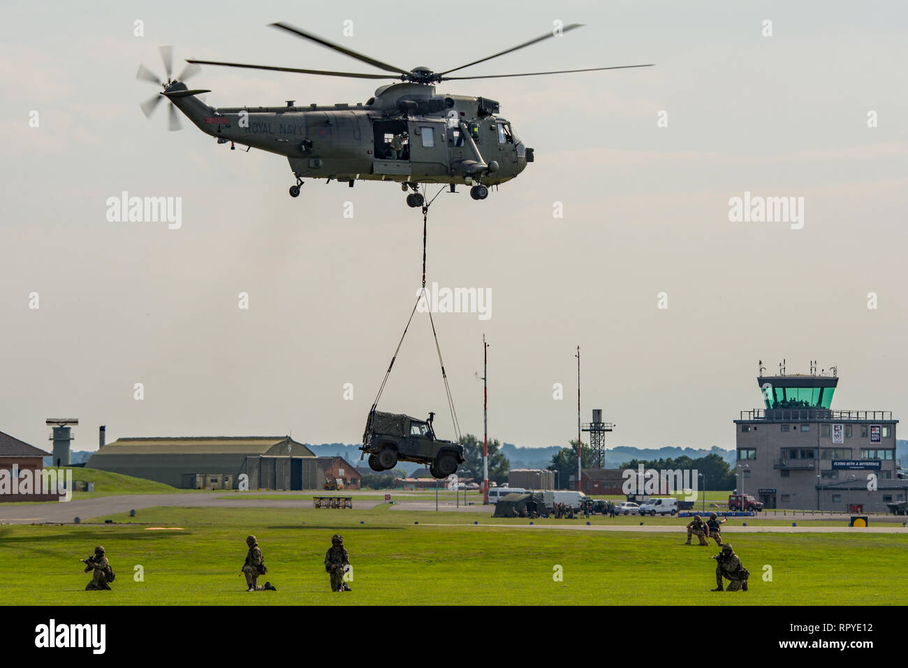 Royal Navy Westland Sea King HC4 helicopter lifting a Land Rover during ...