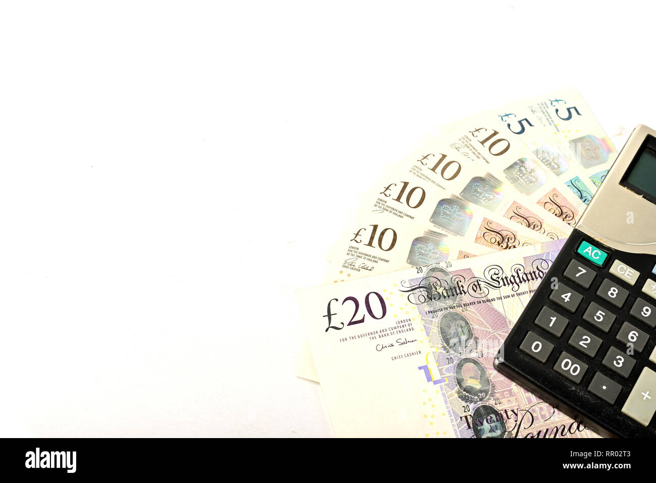 Counting British pound isolated by calculator on white background Stock ...