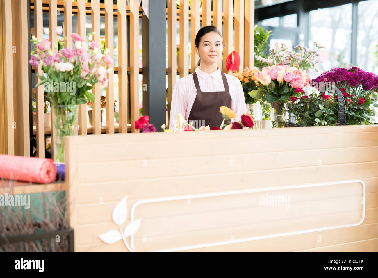 Shop assistant by workplace Stock Photo - Alamy