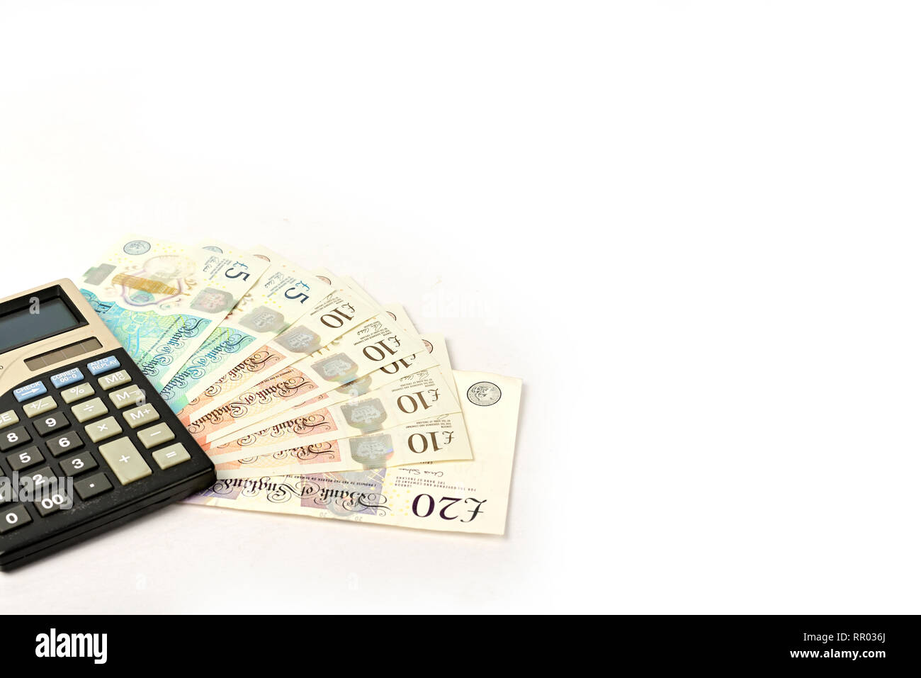 Counting British pound isolated by calculator on white background Stock ...