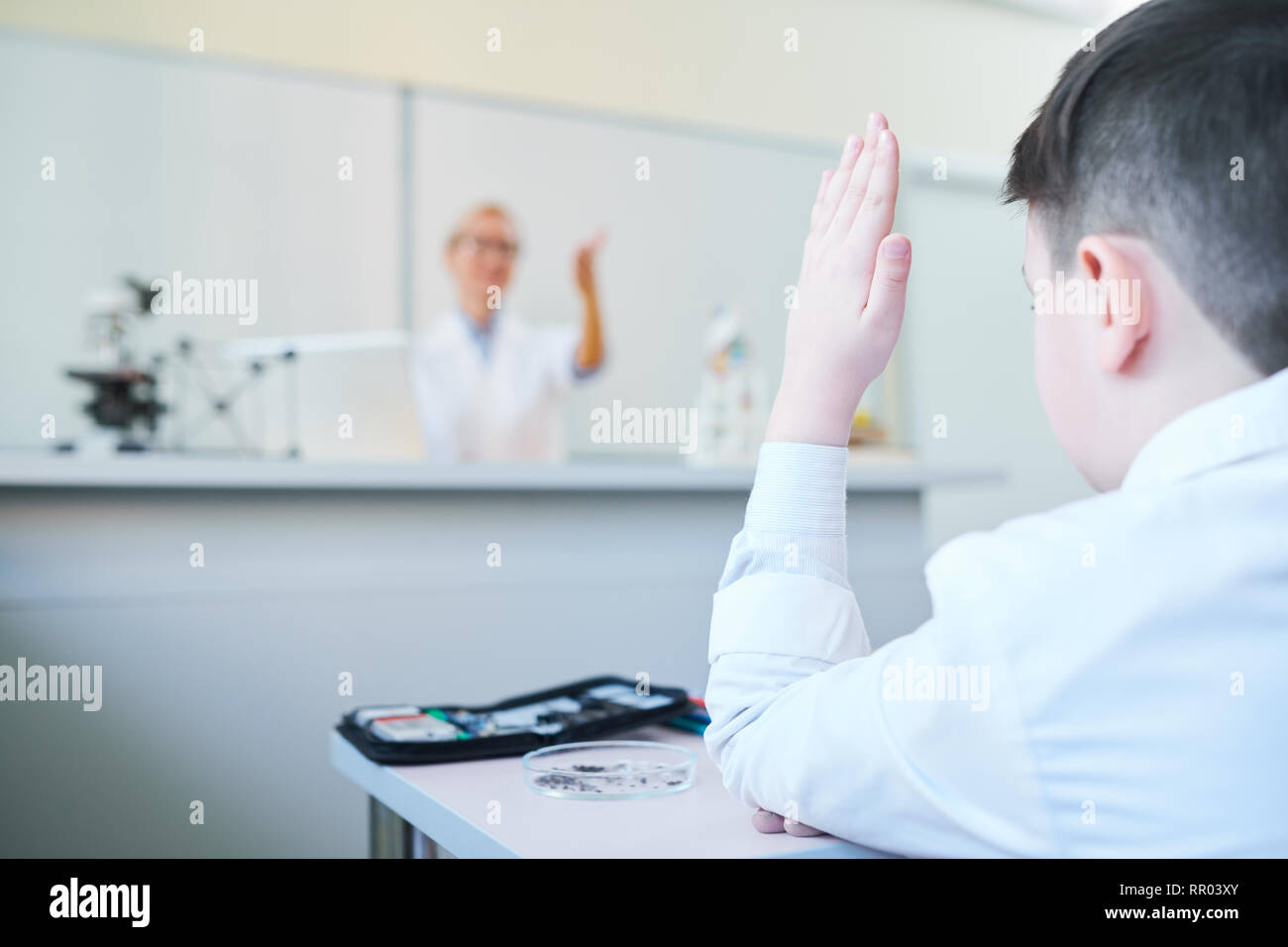 Boy raising hand Stock Photo - Alamy