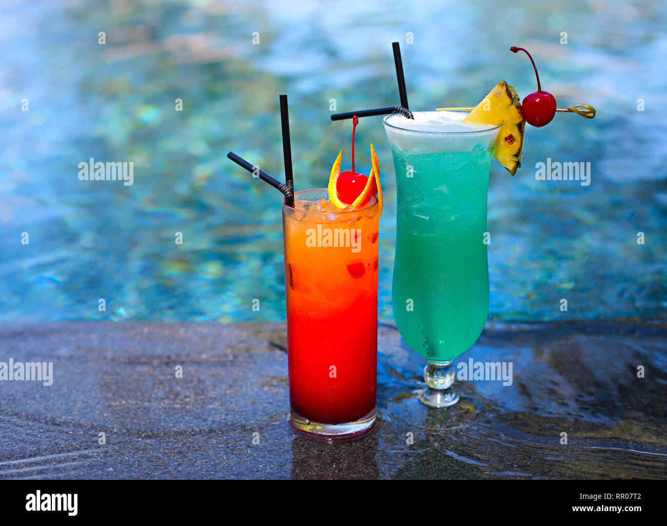 Glass with a bright blue lagoon and tequila sunrise cocktails by the ...