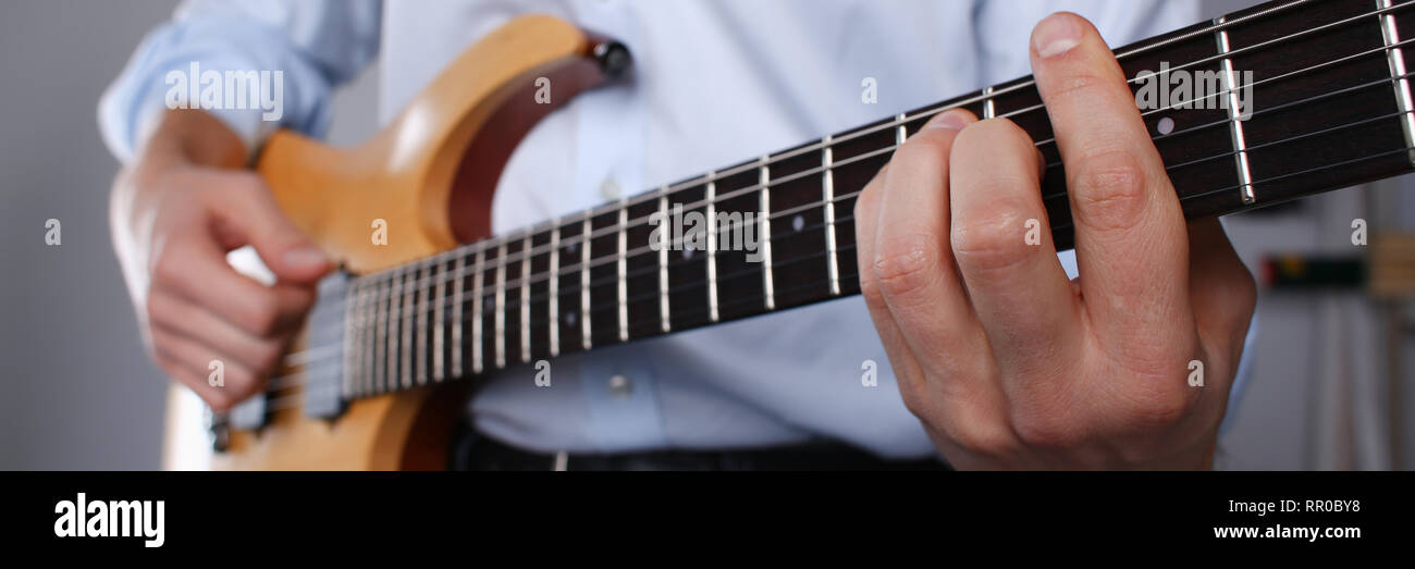 Male arms playing classic shape electric guitar Stock Photo - Alamy