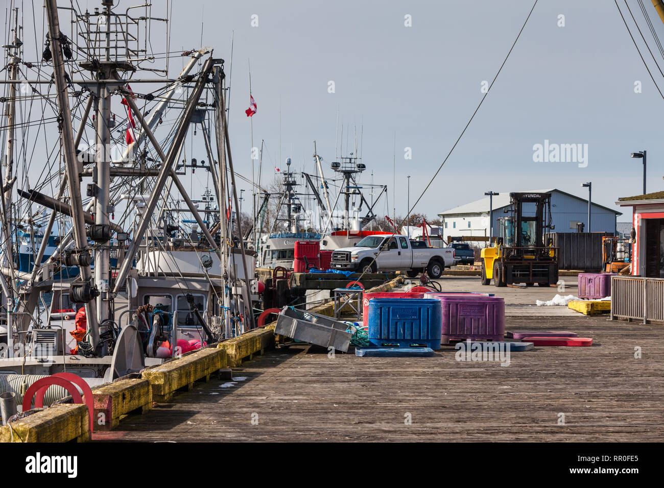 Busy waterfront scene of a commercial fishing vessel unloading at a ...