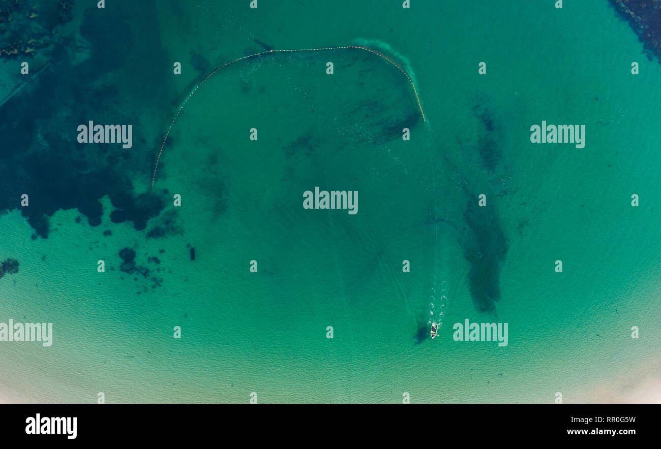 Bird view over at a fishing boat while pulling a net Stock Photo - Alamy