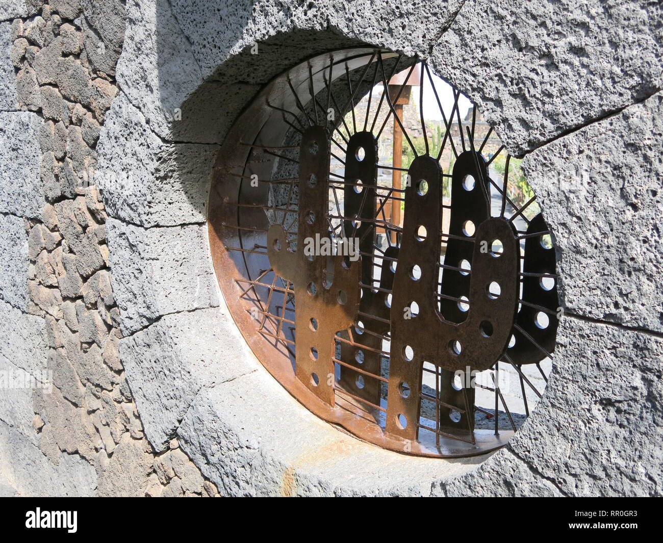 An oval cut-through in the wall, with metal cactus shapes provides the ...
