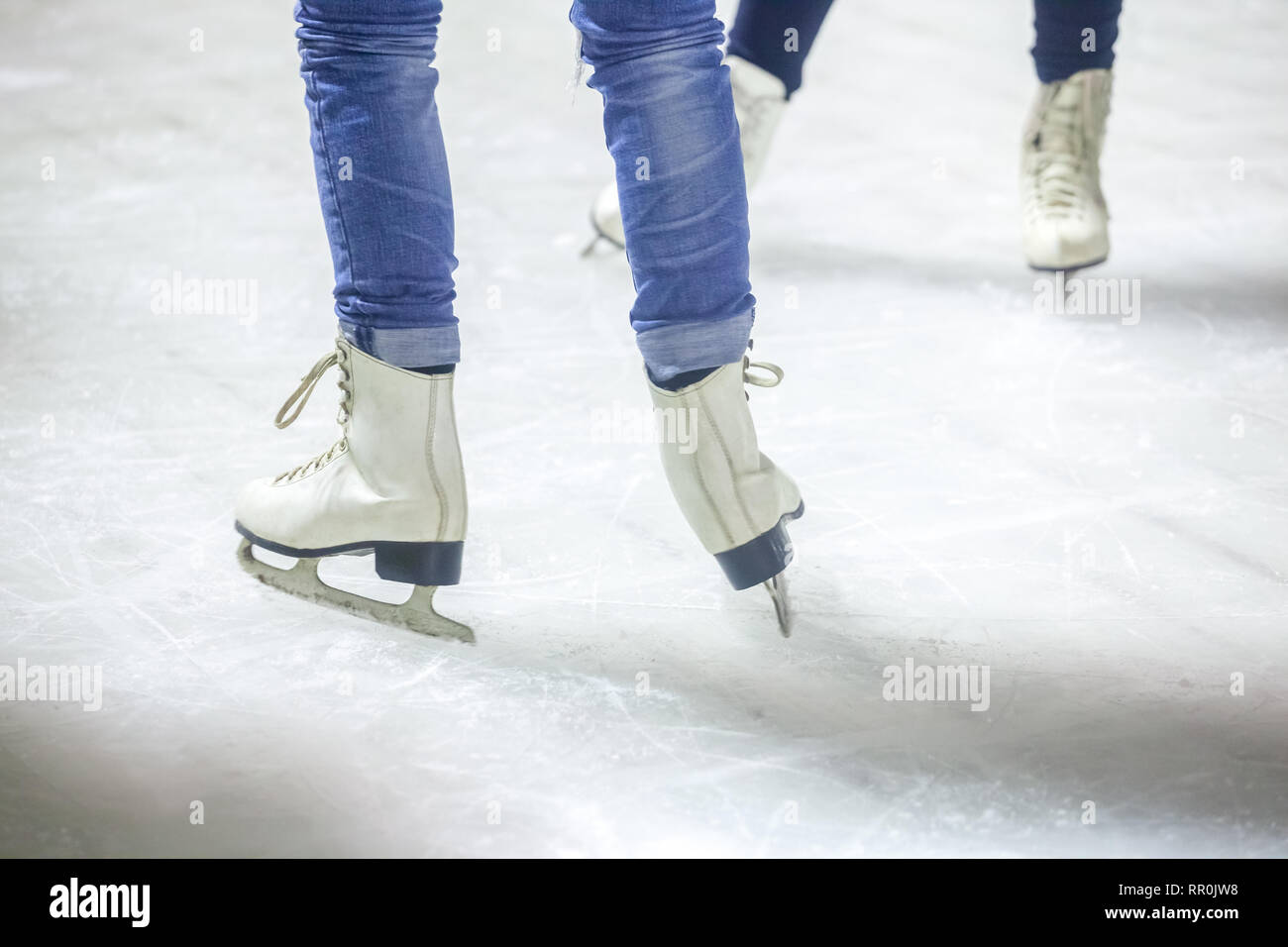feet on the skates of a person rolling on the ice rink Stock Photo - Alamy
