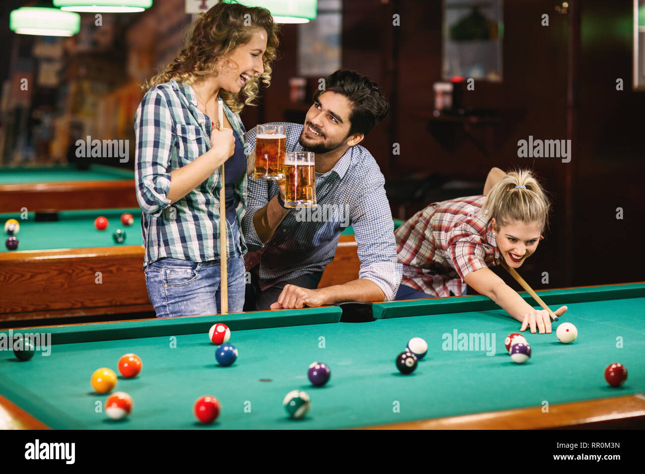billiard game. group of fun friends playing pool together Stock Photo ...