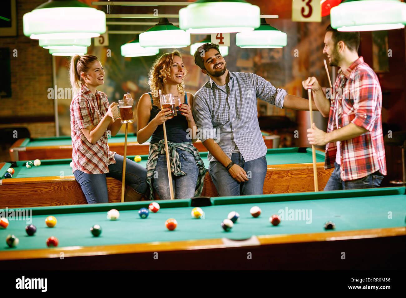 fun with smiling friends on billiard games in bar Stock Photo - Alamy