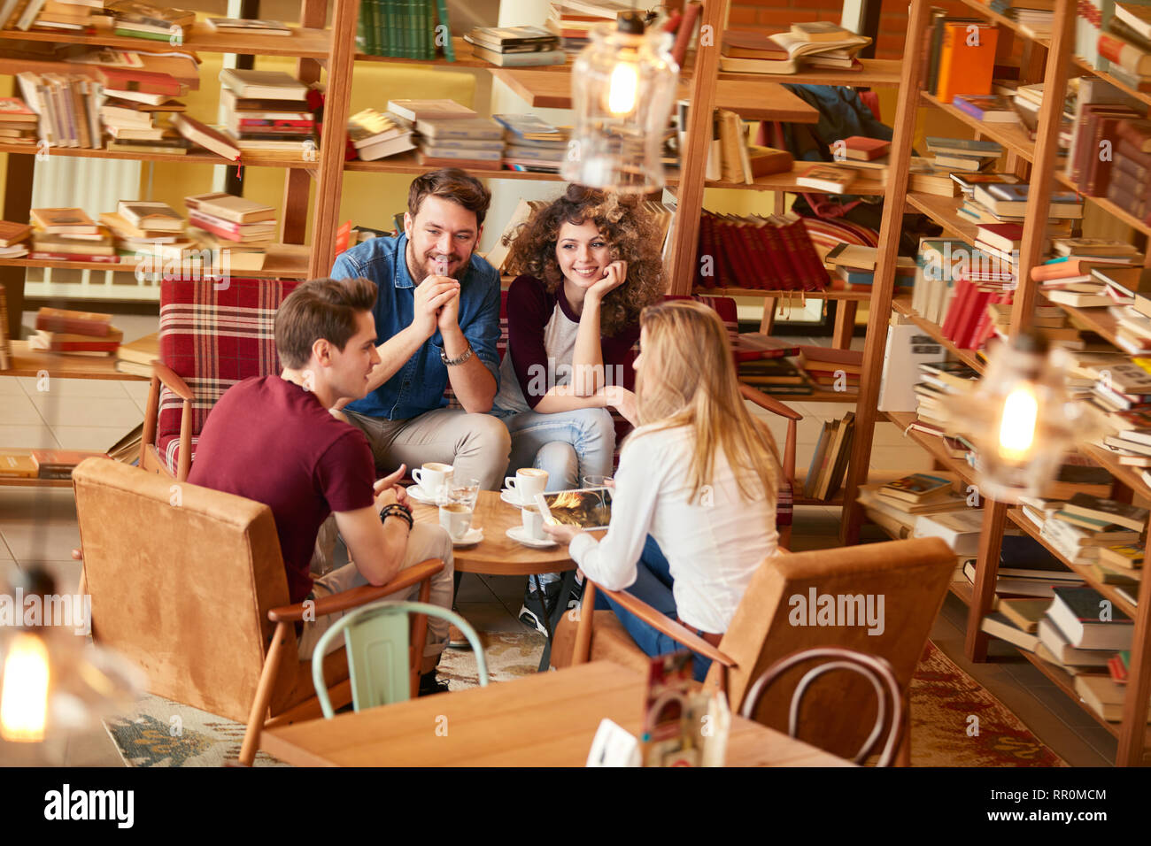 Two couple of students in conversation in library Stock Photo - Alamy