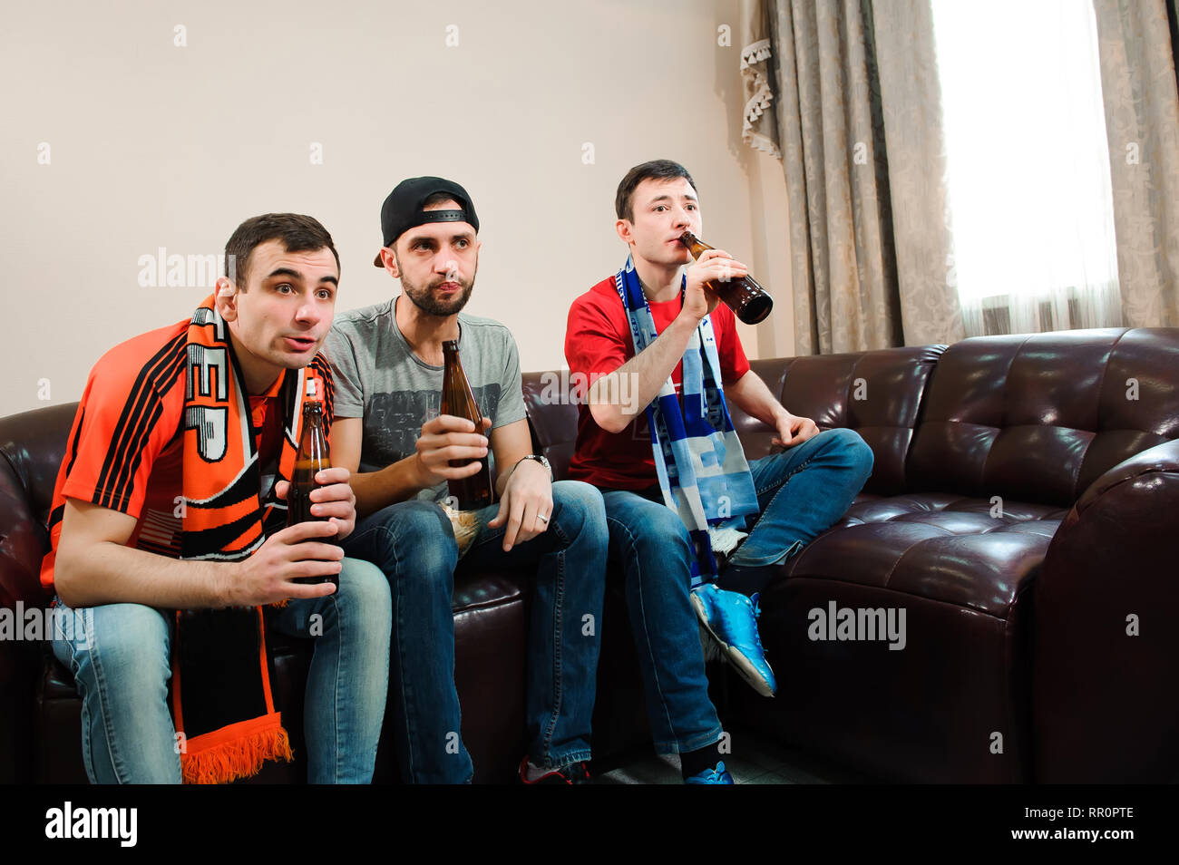 Football fans. Men drink beer, eat chips and root for football Stock ...