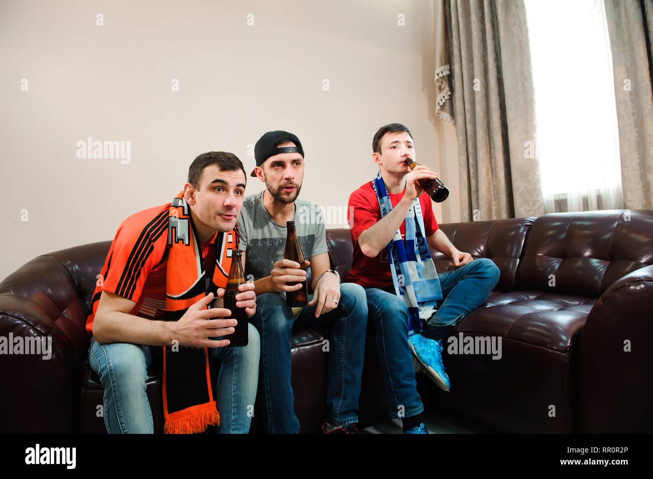 Football fans. Men drink beer, eat chips and root for football Stock ...