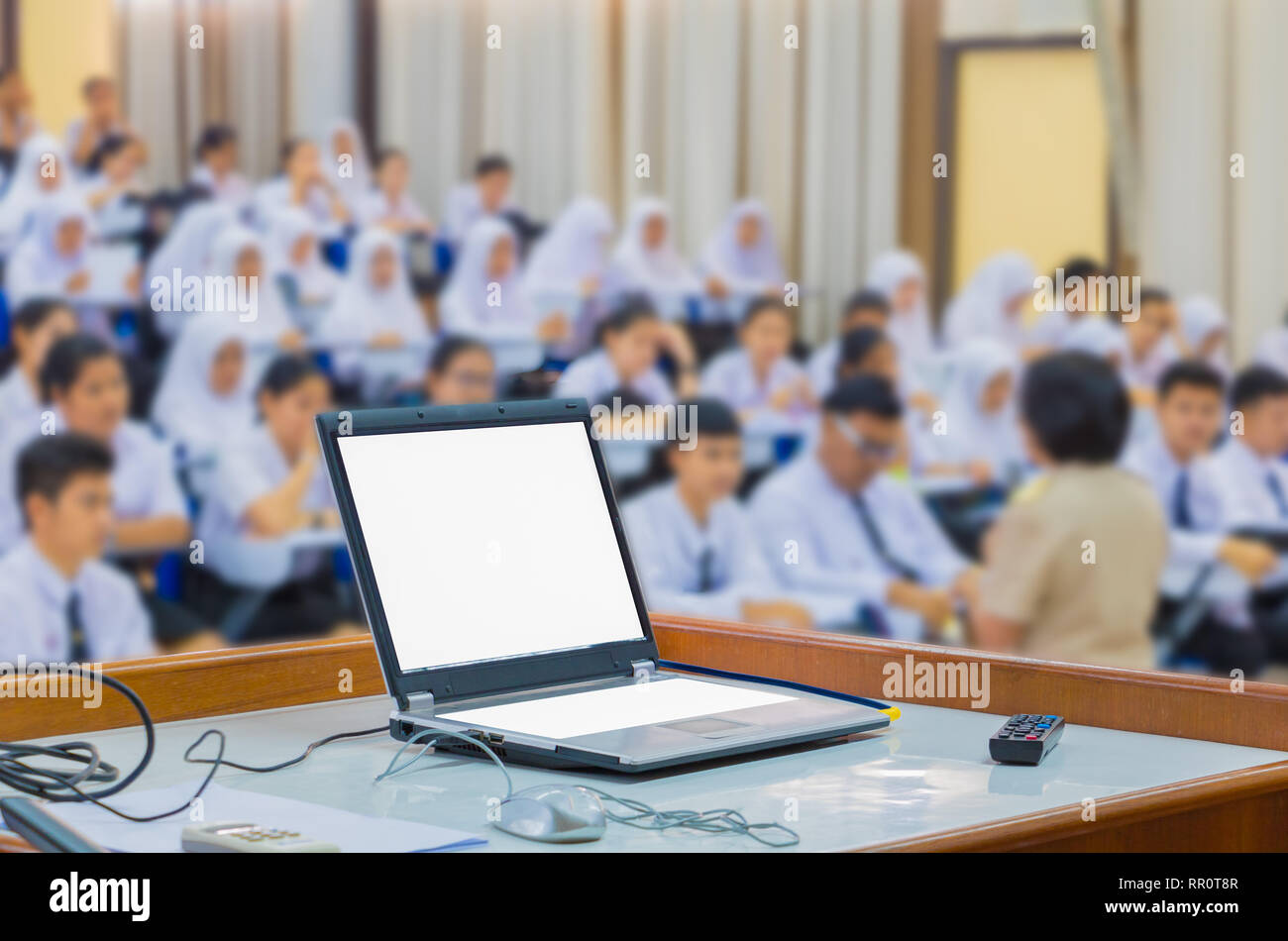 computer on the table and group students blur sitting in the a ...