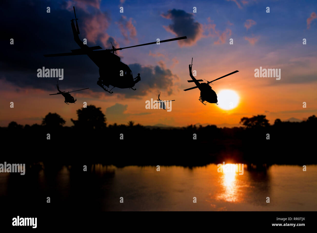 soldier silhouette in rappelling climb down from helicopter on sunset ...