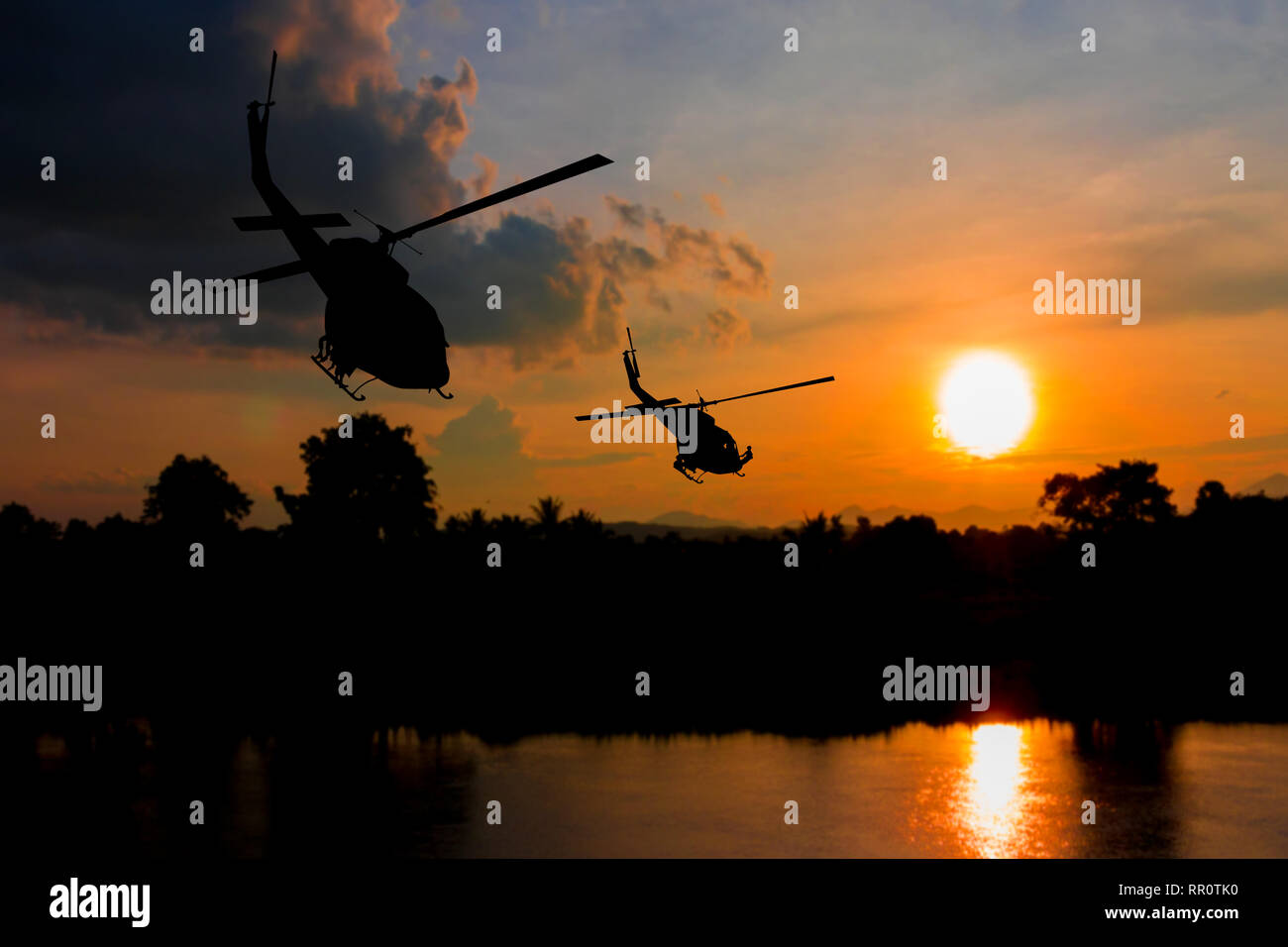 soldier silhouette in rappelling climb down from helicopter on sunset ...