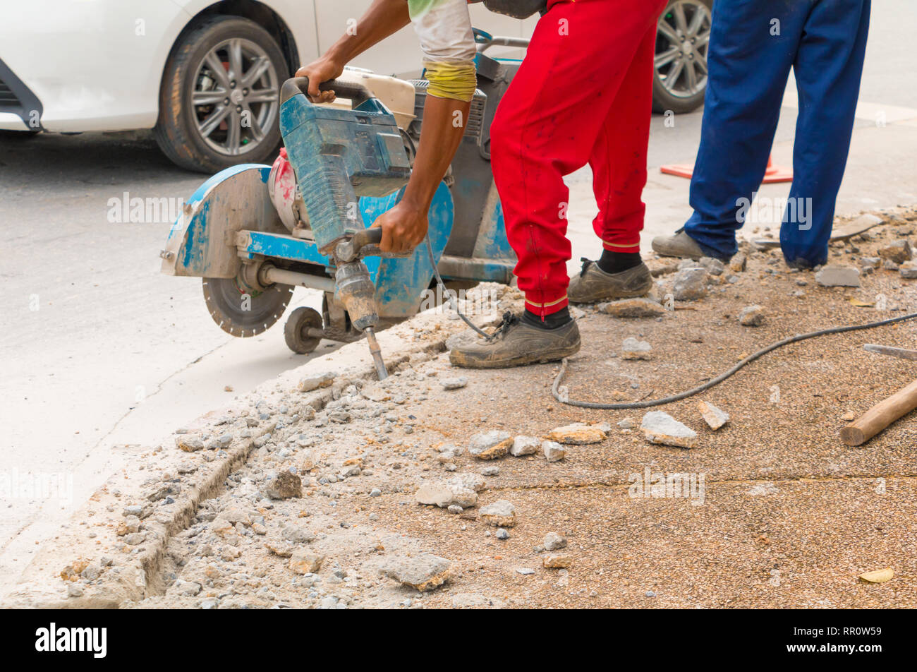 construction drilling repair worker on road surface with heavy duty ...