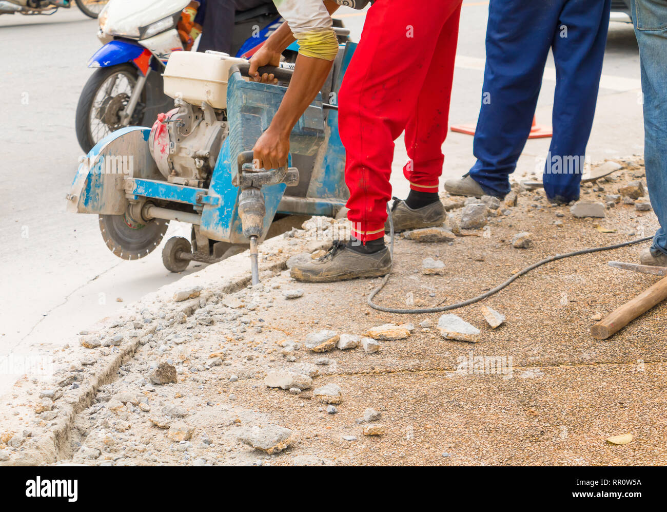 construction drilling repair worker on road surface with heavy duty ...