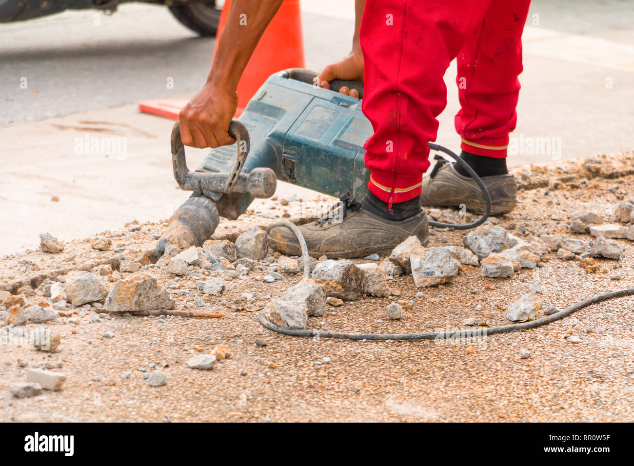 construction drilling repair worker on road surface with heavy duty ...