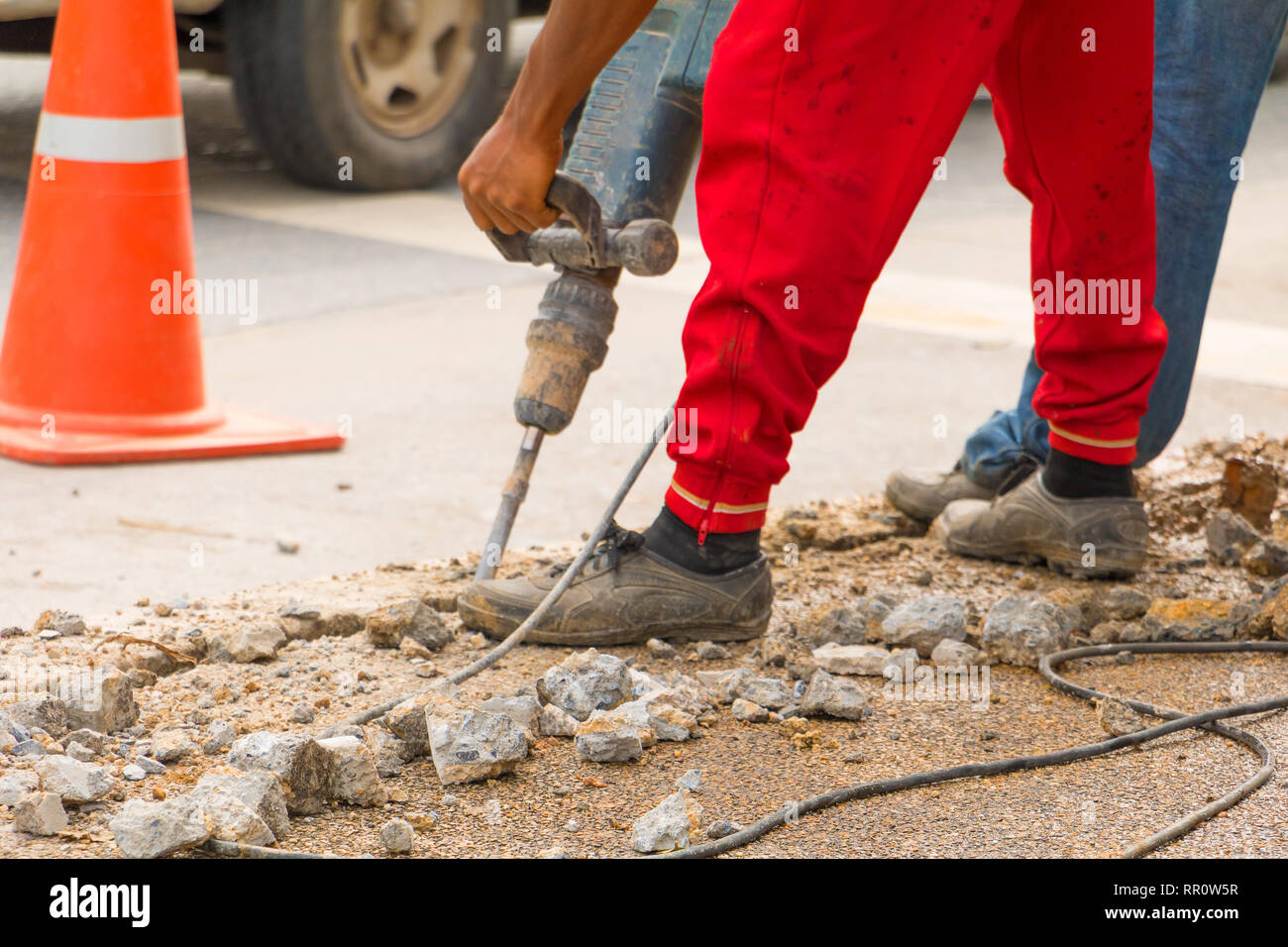 construction drilling repair worker on road surface with heavy duty ...