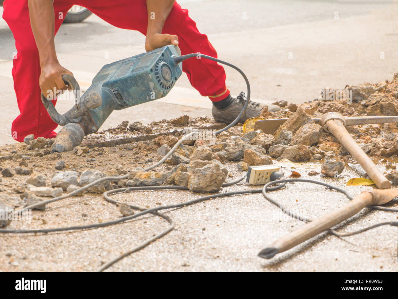construction drilling repair worker on road surface with heavy duty ...