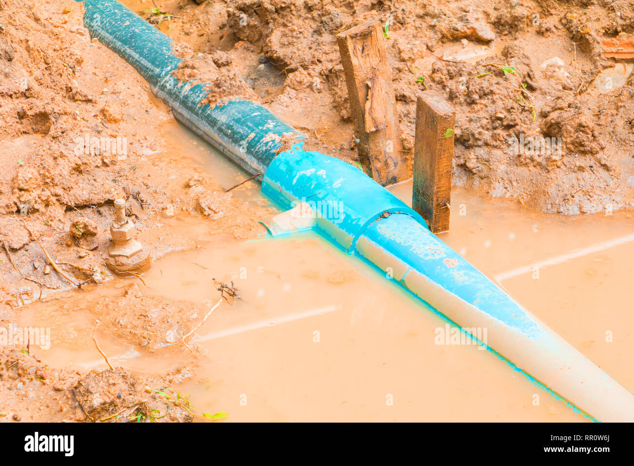 repair plumbing PVC broken pipe in hole which has water with copy space ...