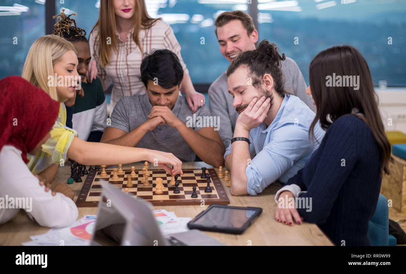 a multiethnic group of business people playing chess while having a ...