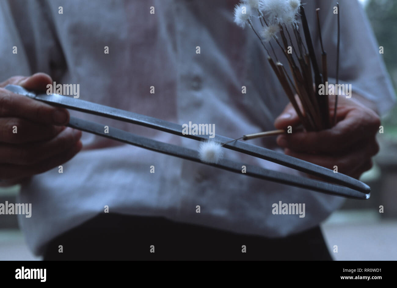 An ear tickler in the Sichuan capital, Chengdu, cleans his instruments ...