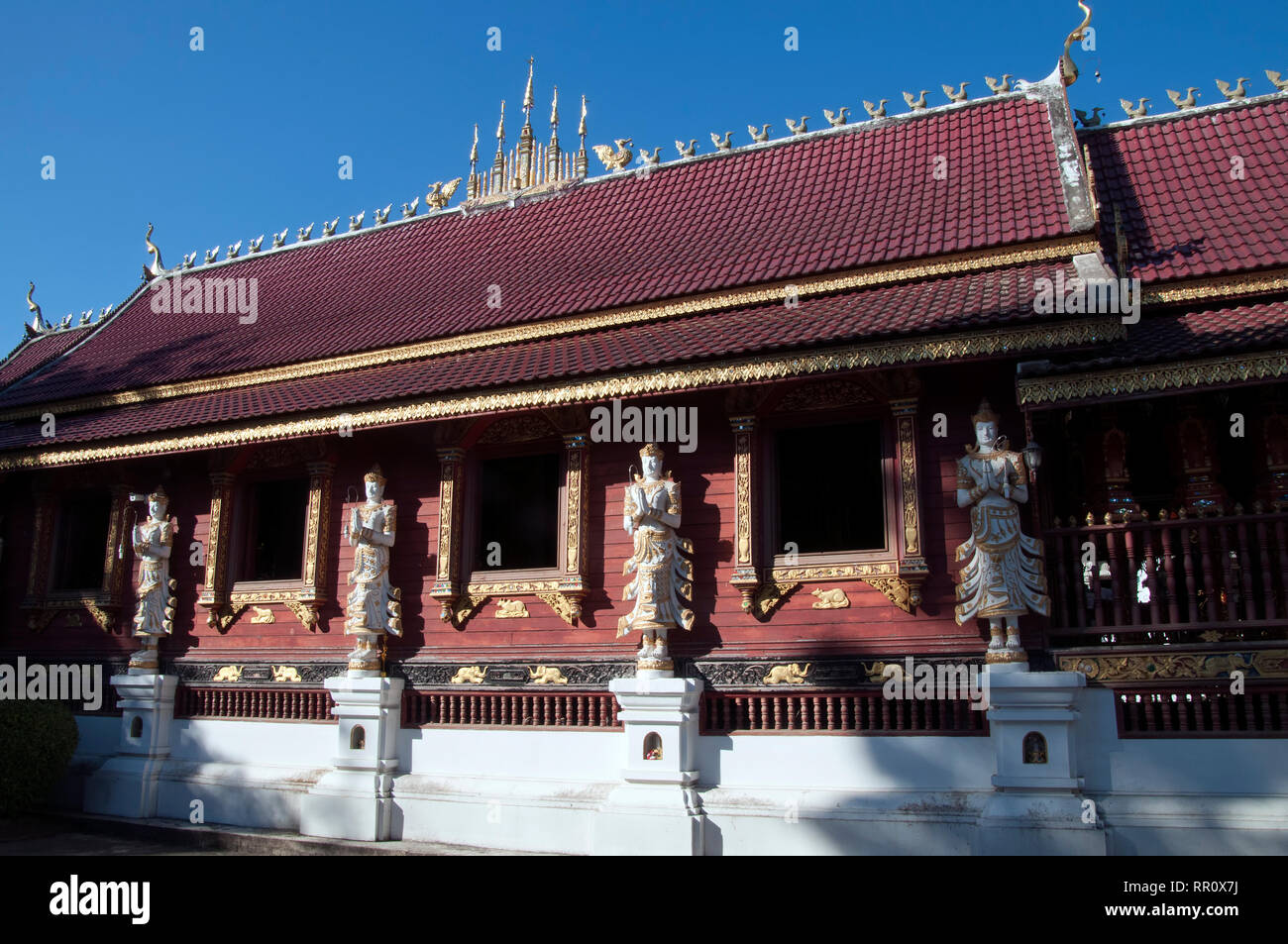 Chiang Rai Thailand, statues holding lanterns along red wall at Wat ...