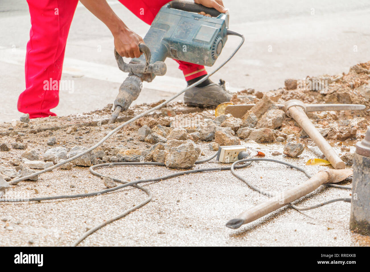 construction drilling repair worker on road surface with heavy duty ...