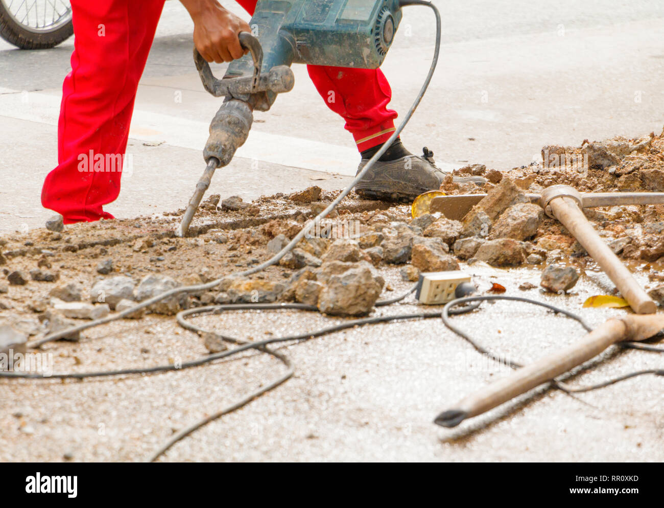 construction drilling repair worker on road surface with heavy duty ...