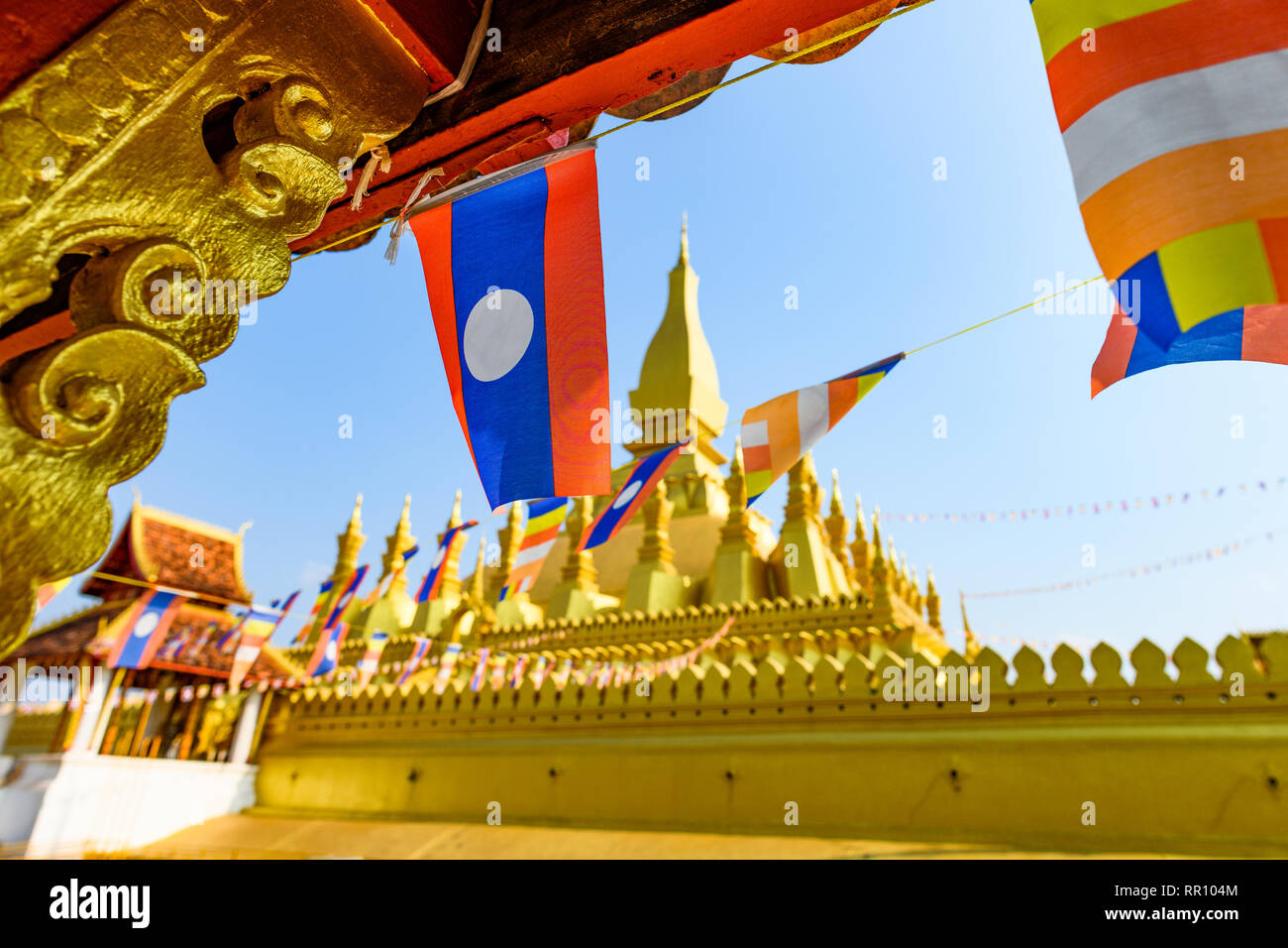 (selective focus) Some Laos flags waving in the foreground with the ...