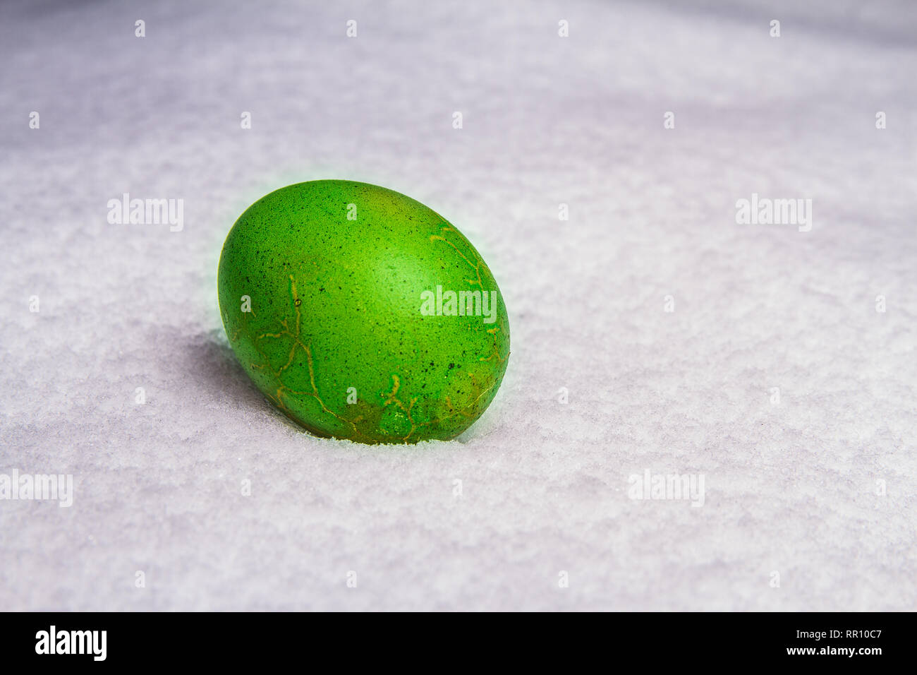 Green easter egg sitting on snow isolated Stock Photo - Alamy