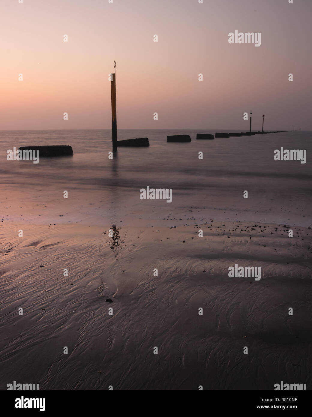 Beach markers at sunrise long exposure on a sandy beach Stock Photo - Alamy