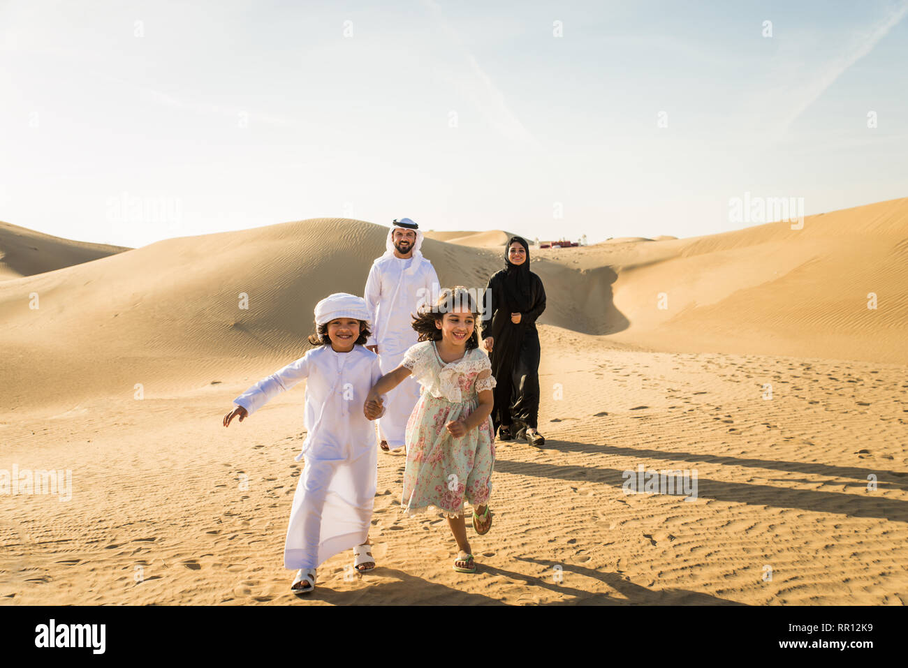 Arabian family with kids having fun in the desert - Parents and ...