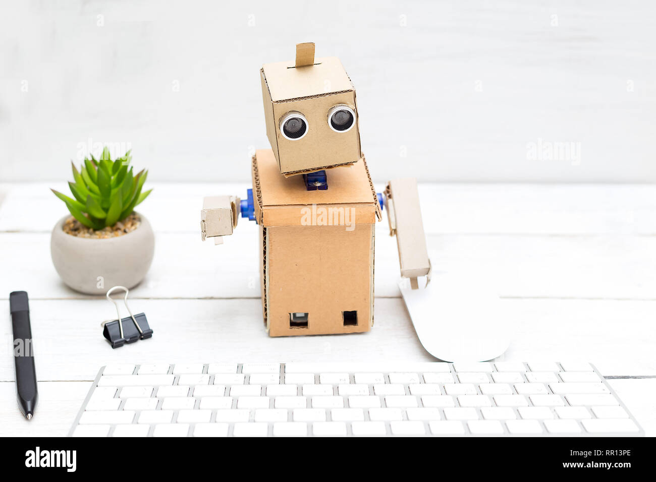 The robot works behind the computer on the keyboard Stock Photo - Alamy
