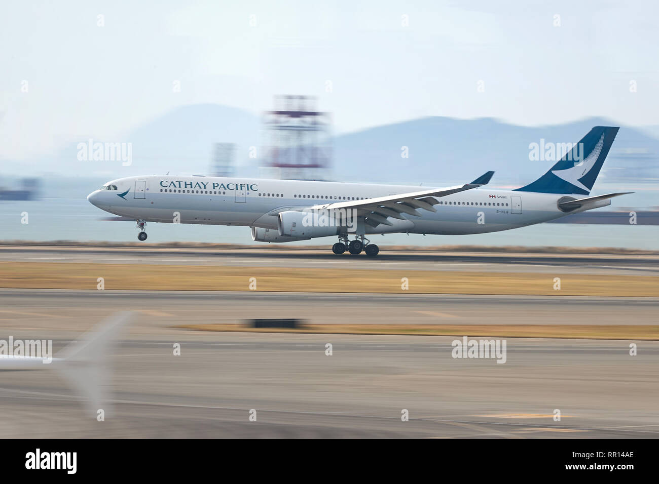 Landing Cathay Pacific passenger airplane moving fast Stock Photo - Alamy