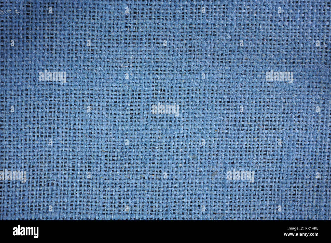 Blue-dyed burlap fabric on a black background Stock Photo - Alamy