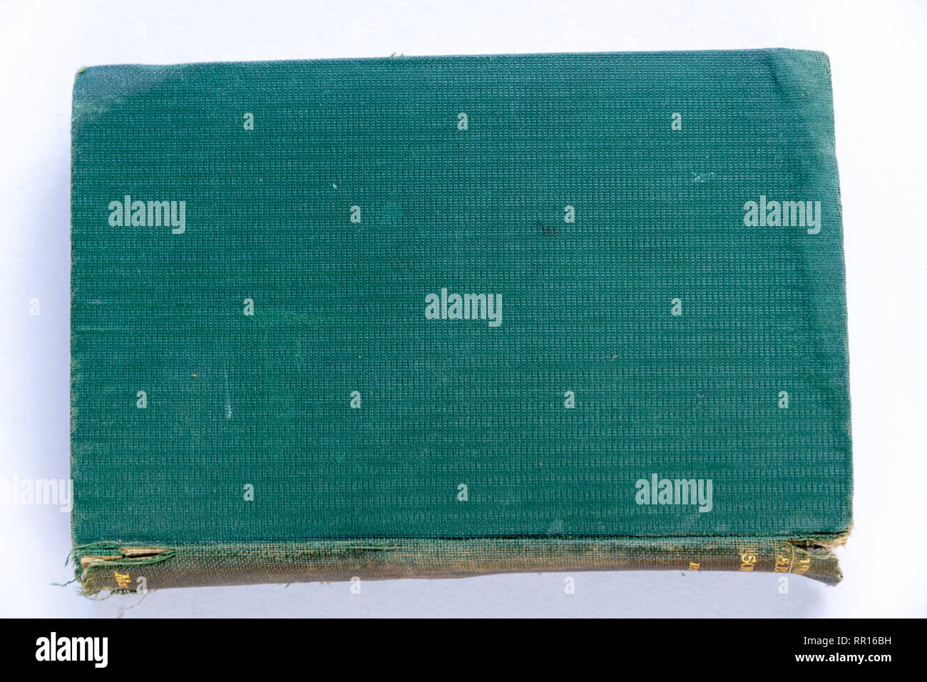 overhead shot of an old and battered green hardback book with a worn ...