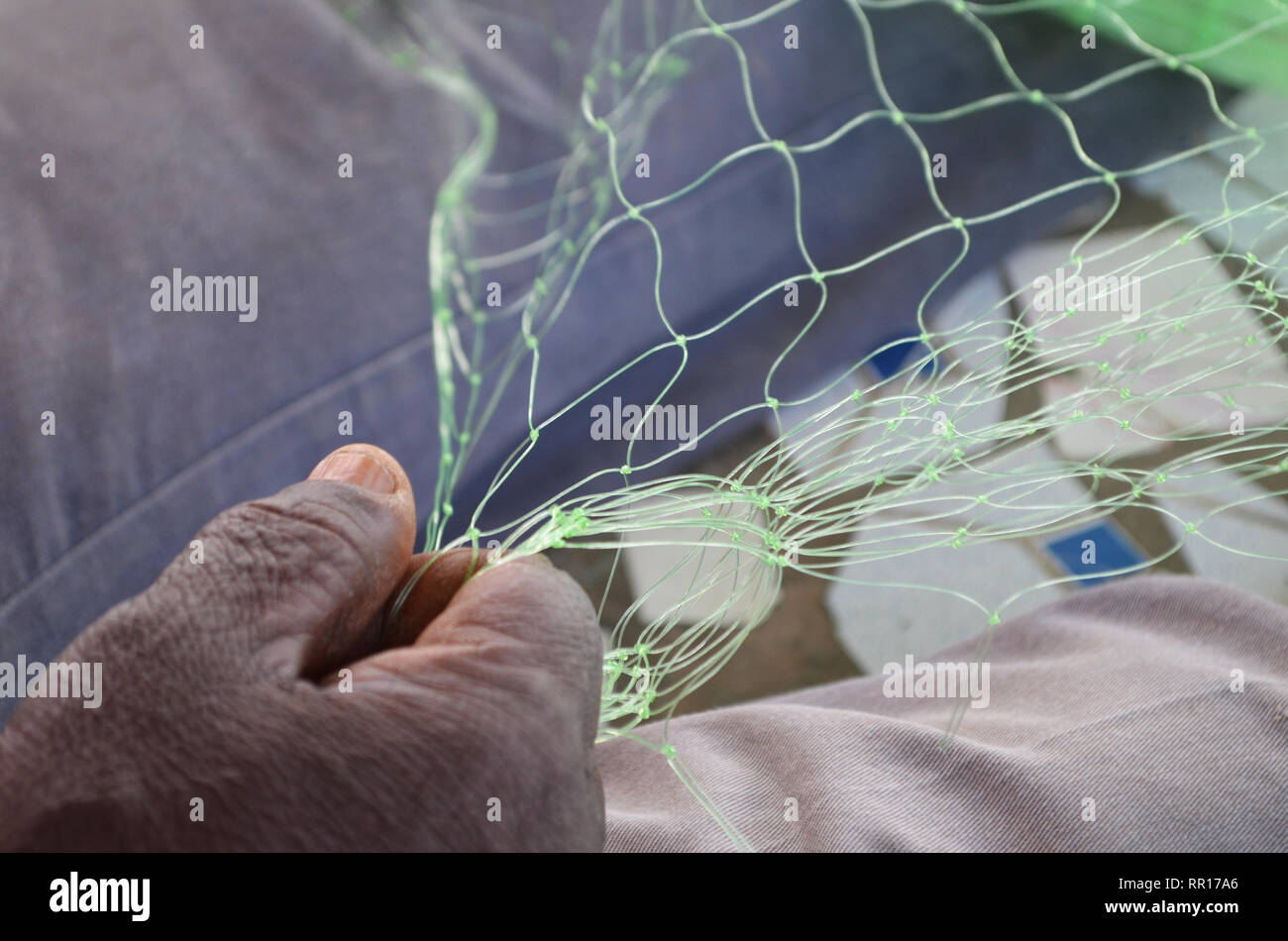 Artisanal fisherman mending nets in Joal-Fadiouth (Senegal Stock Photo ...