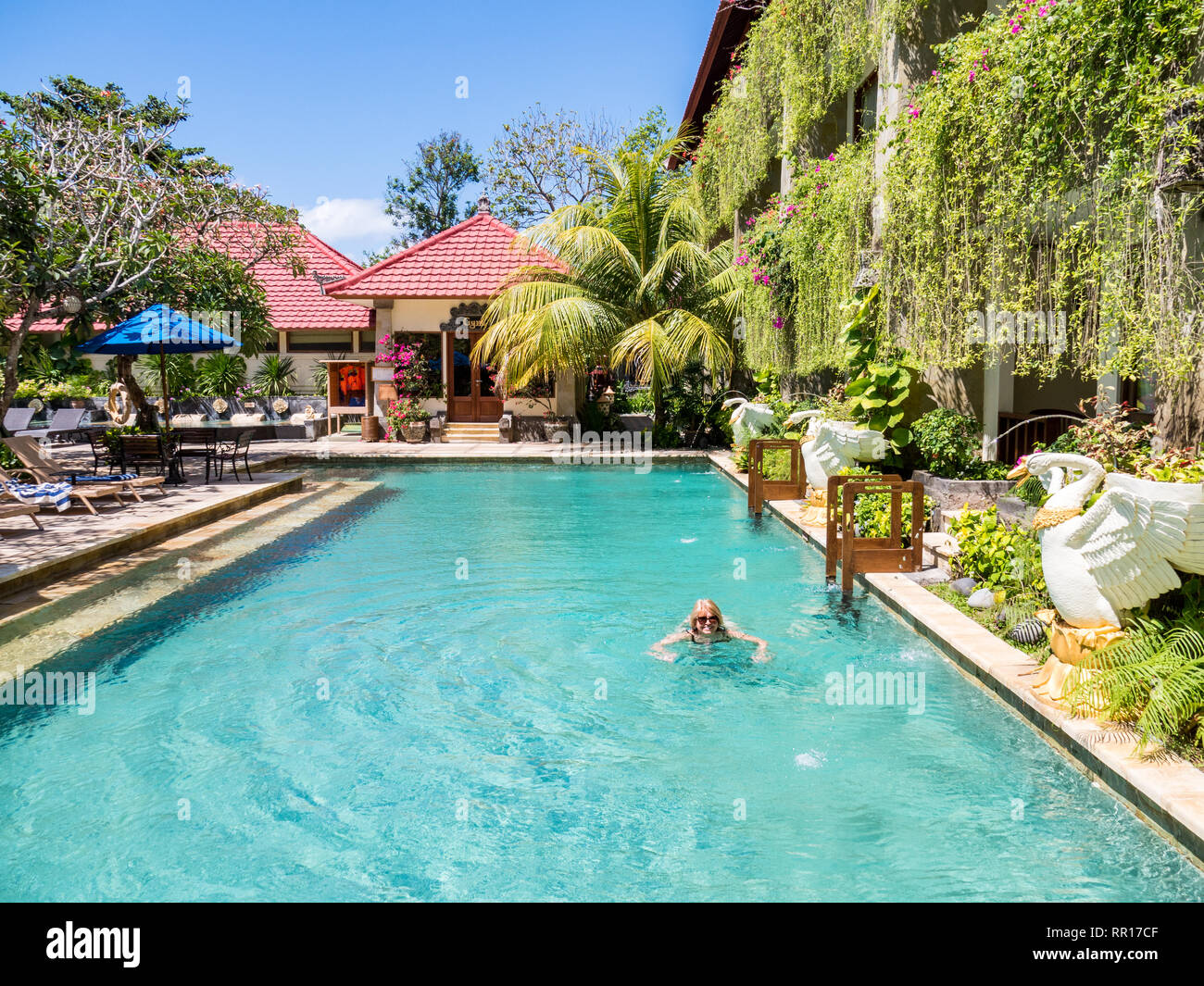 Swimming and relaxing in a pool resort on holiday Stock Photo - Alamy